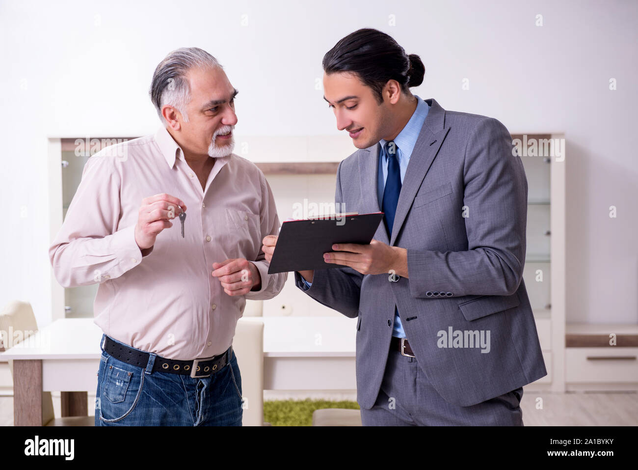 The male real estate agent and male client in the apartment Stock Photo ...