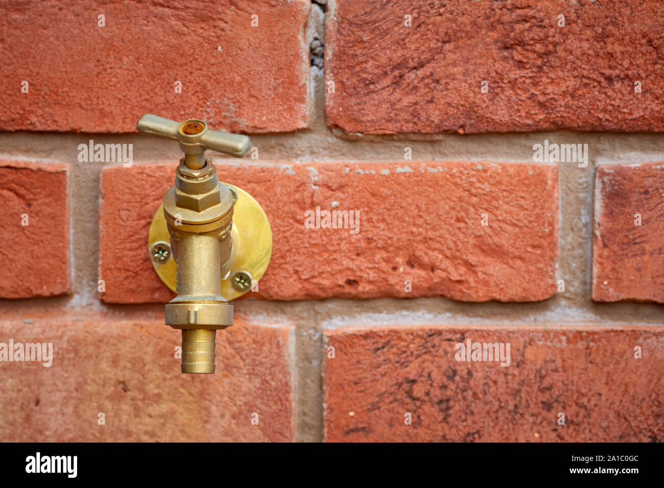 Outside new garden tap on brick house Stock Photo - Alamy
