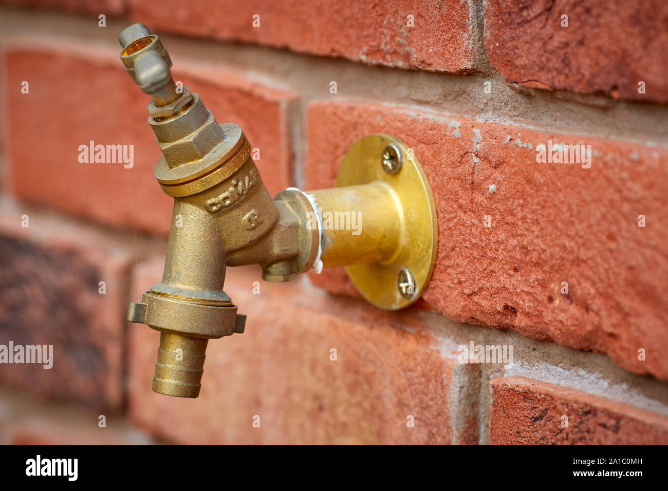 Outside new garden tap on brick house Stock Photo - Alamy
