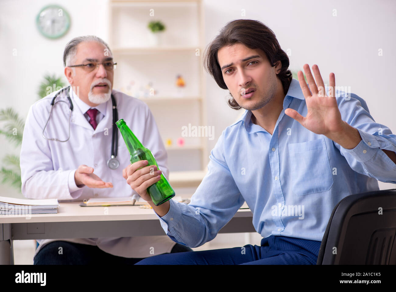 The young male alcoholic visiting old doctor Stock Photo - Alamy