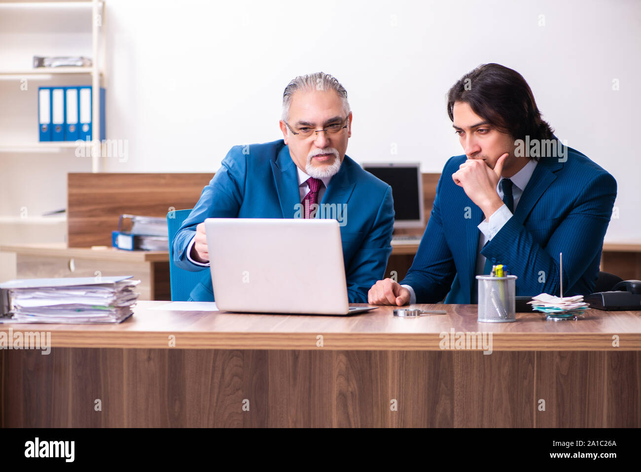 The young and old employees working together in the office Stock Photo ...