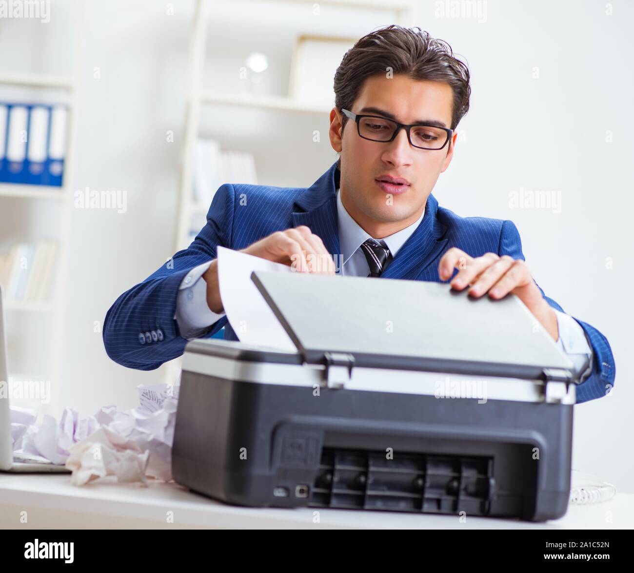 The businessman angry at copying machine jamming papers Stock Photo - Alamy
