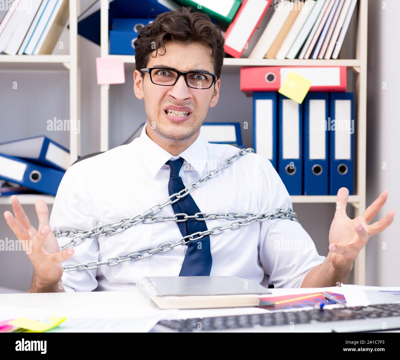 The employee attached and chained to his desk with chain Stock Photo ...