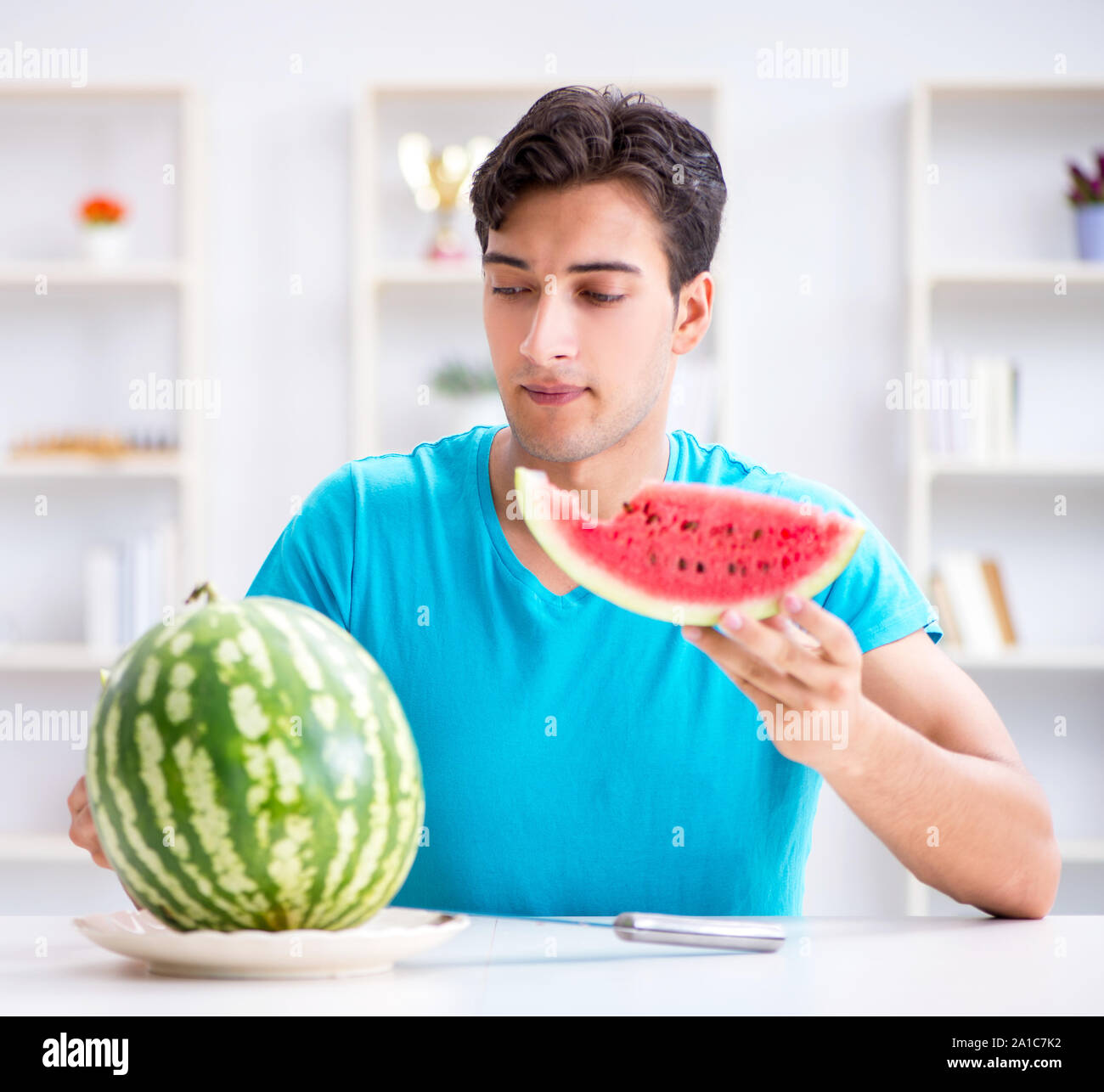 The man eating watermelon at home Stock Photo - Alamy