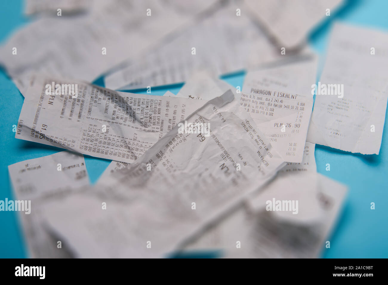 Pile of shopping receipts on a blue background Stock Photo - Alamy