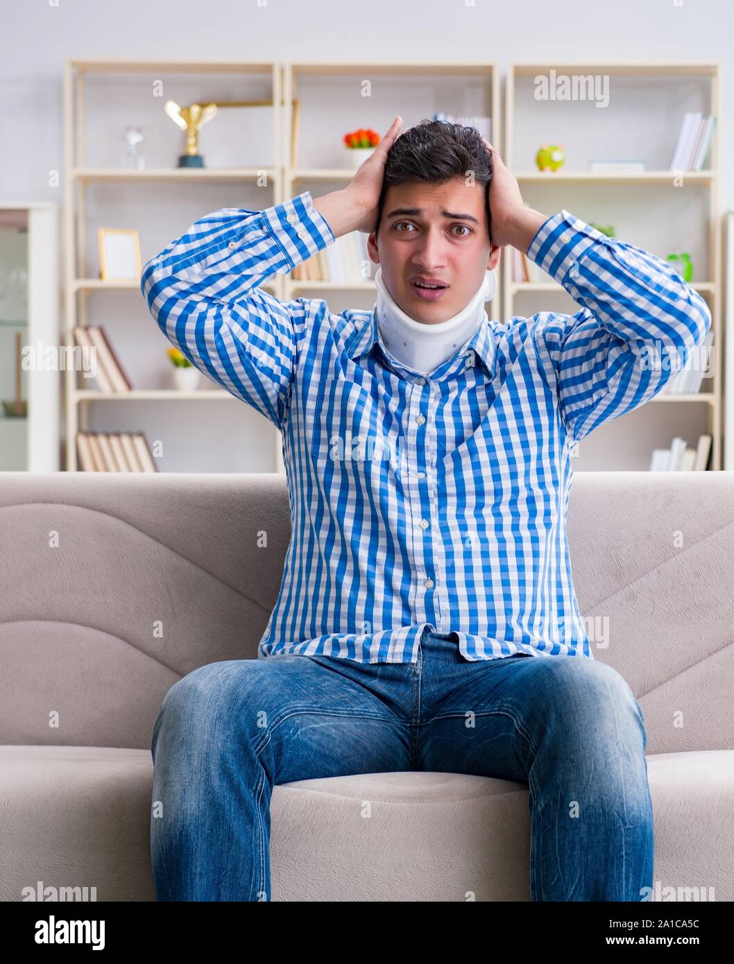 Young man suffering a neck spine head trauma wearing a cervical collar ...