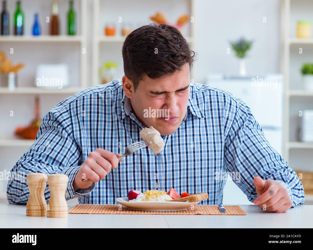 The man eating tasteless food at home for lunch Stock Photo - Alamy