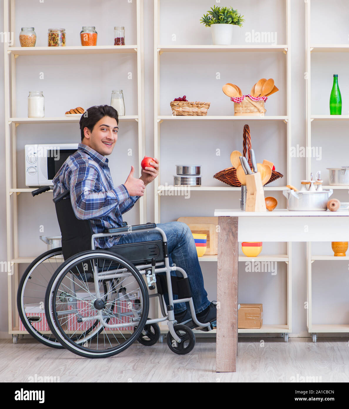 The disabled young man husband working in kitchen Stock Photo - Alamy