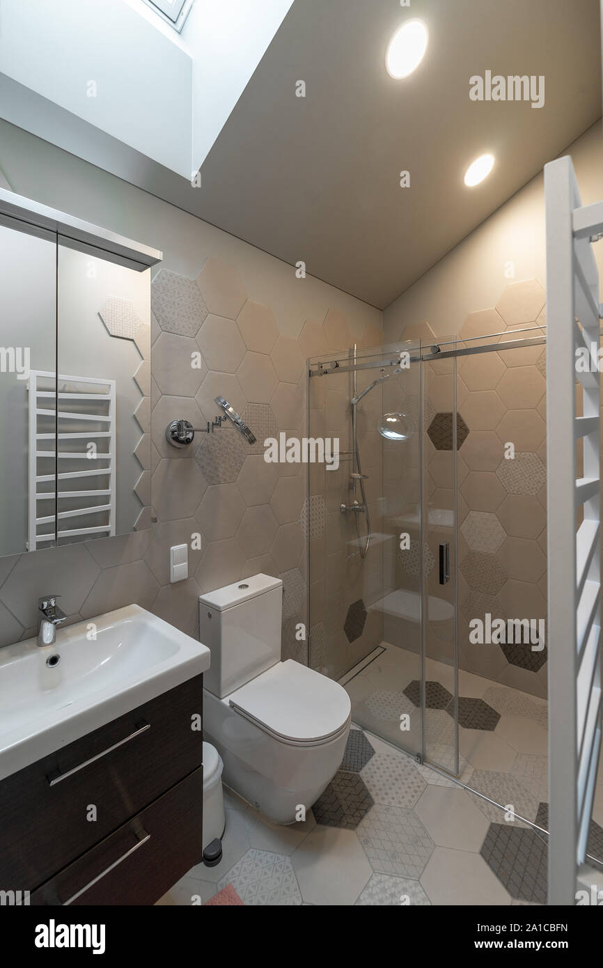 Bathroom in the attic. On the wall - towel radiator. Shower behind ...