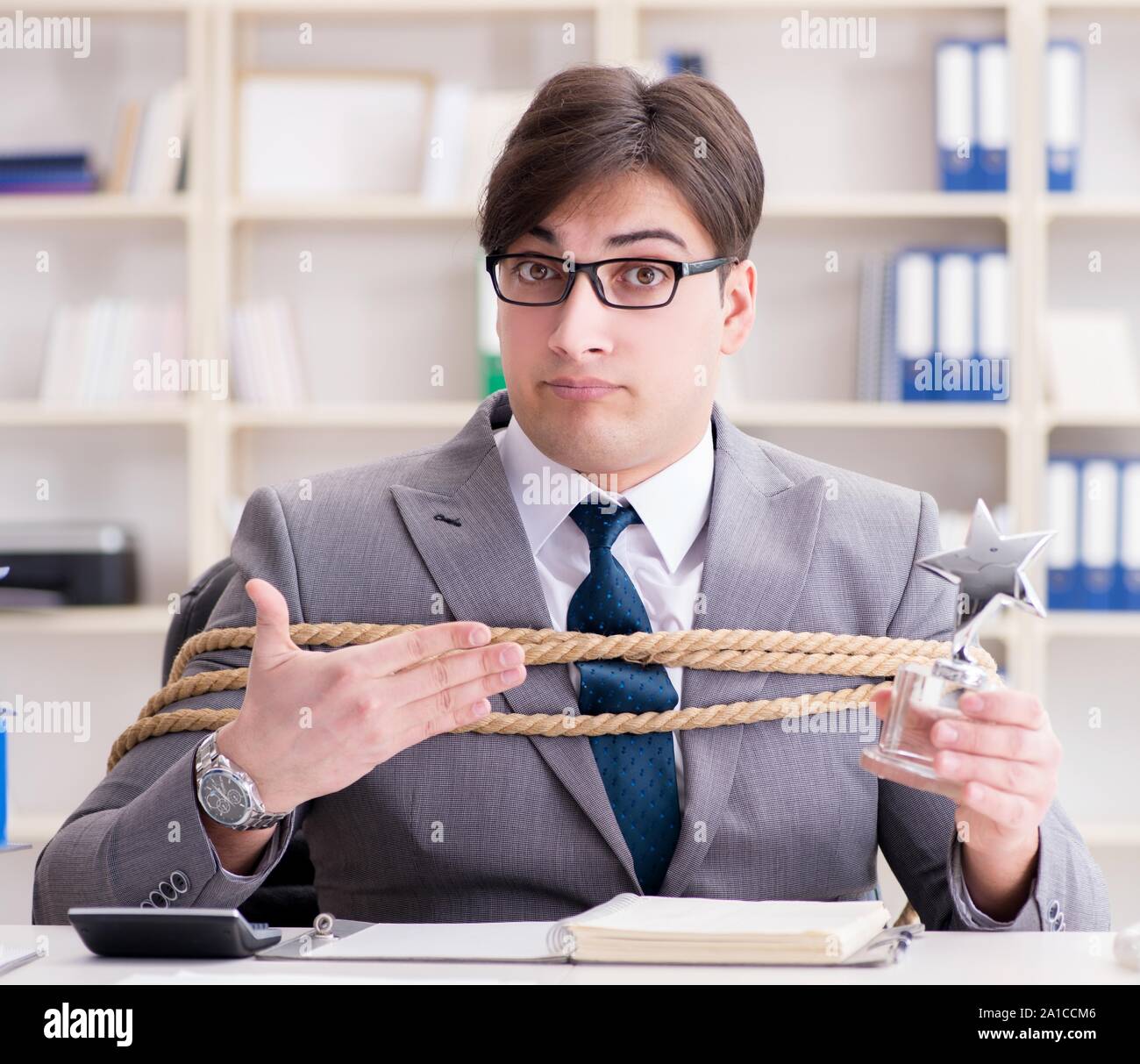 The businessman tied up with rope in office Stock Photo - Alamy