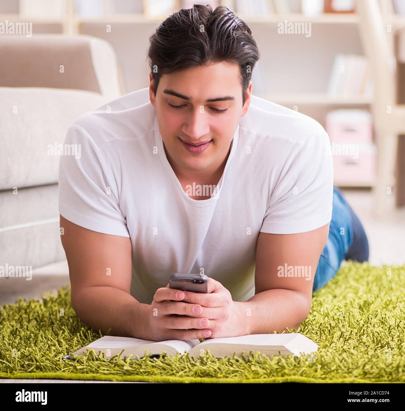 The man reading book at home on floor Stock Photo - Alamy