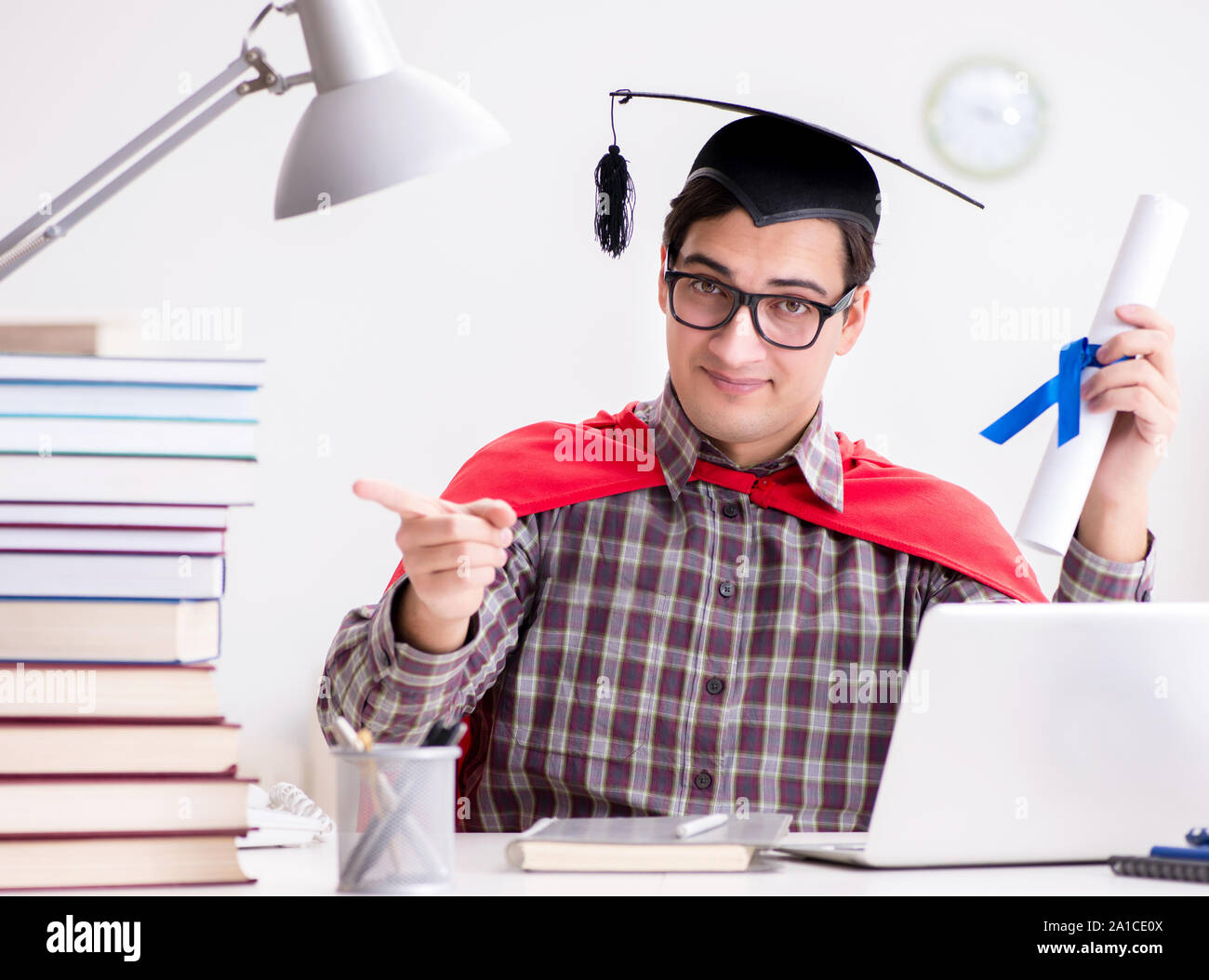 The super hero student wearing a mortarboard studying Stock Photo - Alamy