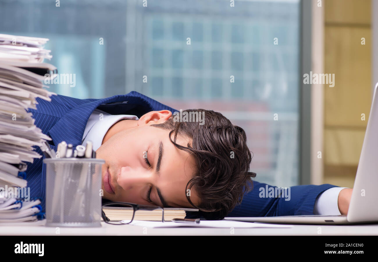 The workaholic businessman overworked with too much work in office ...