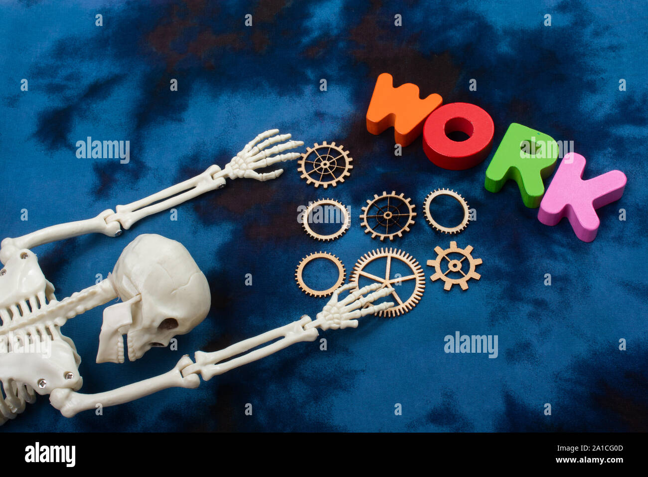 Artificial skeleton, work wording and wooden cogwheels as industry ...