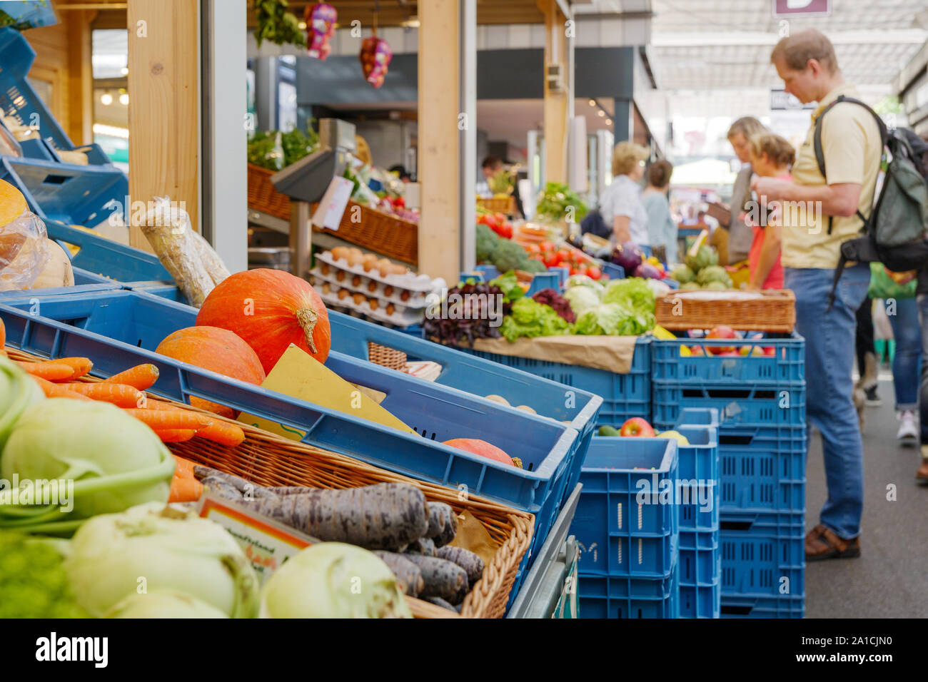 Vegetables sell on row of blue plastic basket in front of stall outside ...