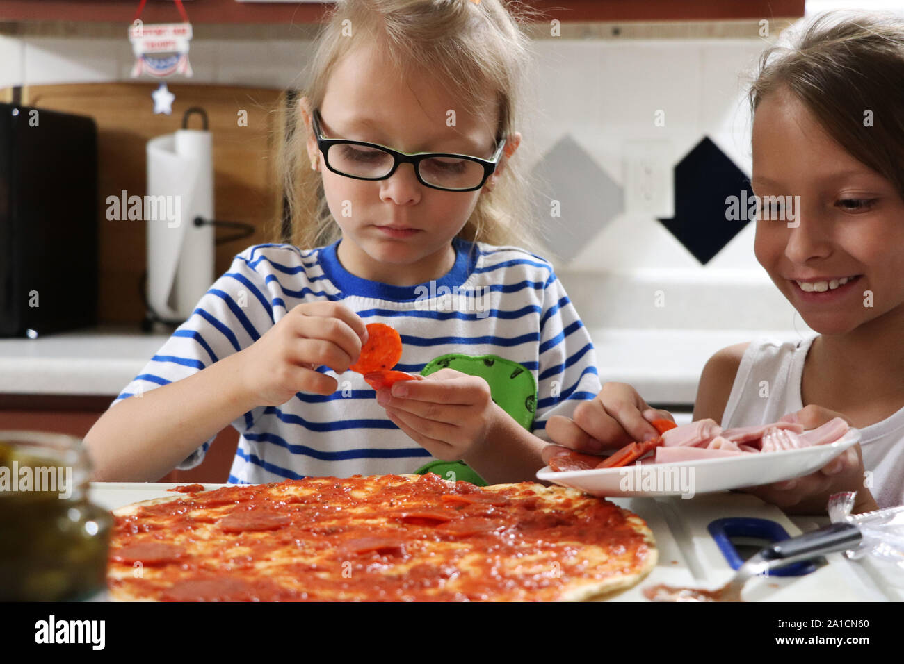 Two young sisters preparing their dinner together Stock Photo - Alamy