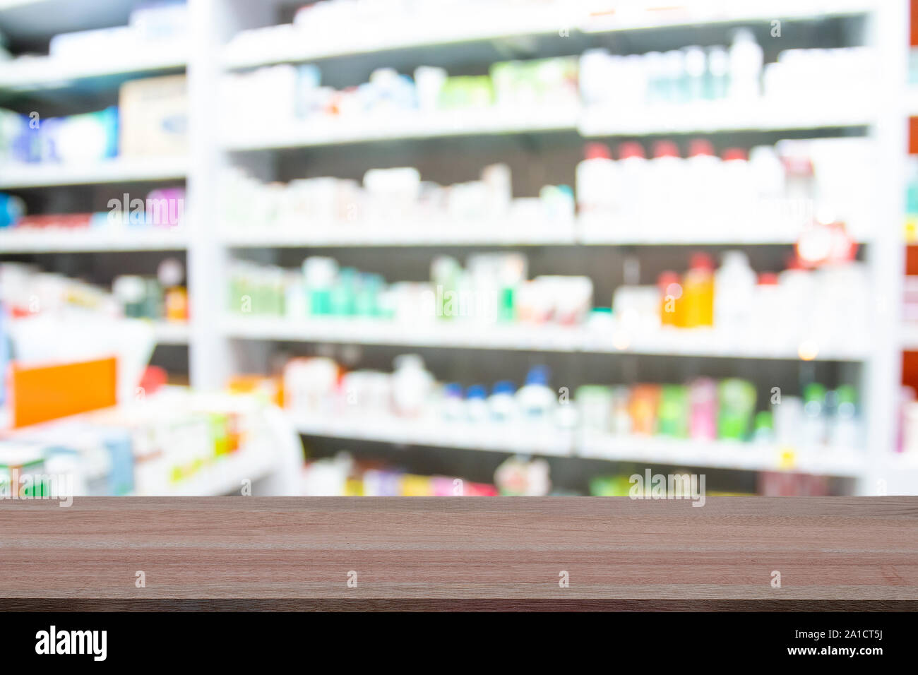 Wooden table top on blur images of medicines in pharmacies background ...