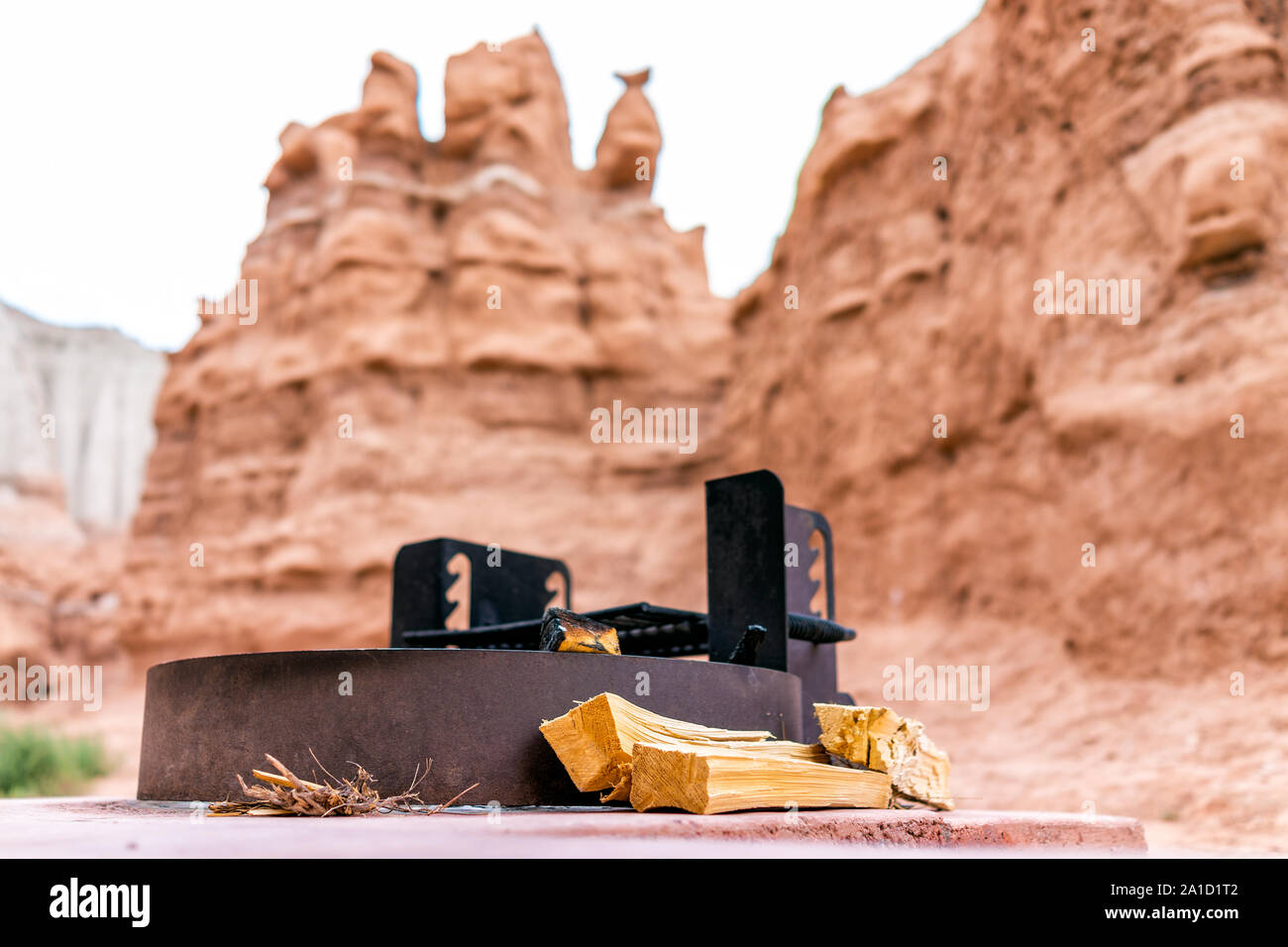 Campfire fire pit grill low angle view with logs and desert landscape ...