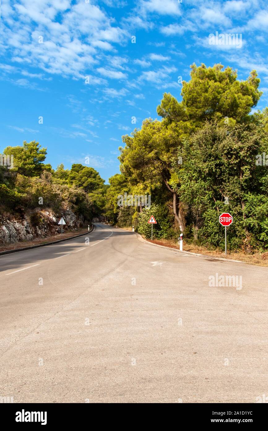 Road on the Croatian island of Lastovo. Forest junction with stop road ...