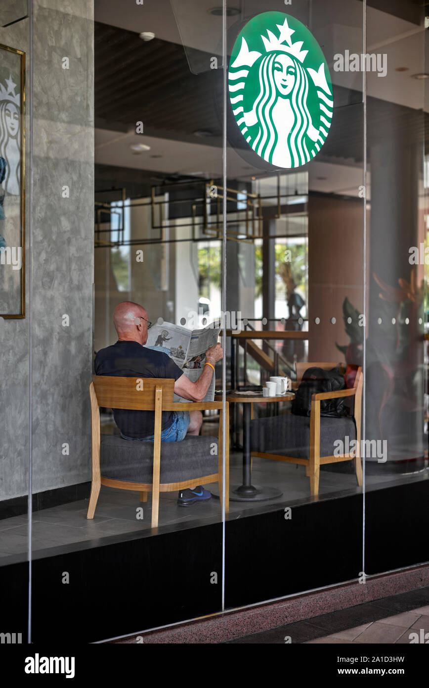 Starbucks restaurant through the window with a man reading the ...