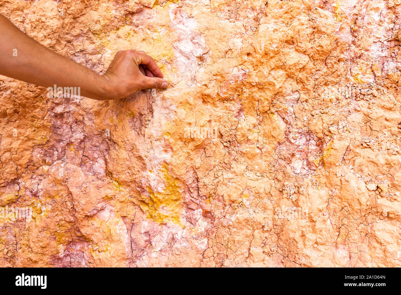 Man touching orange rock formations wall closeup at Bryce Canyon ...