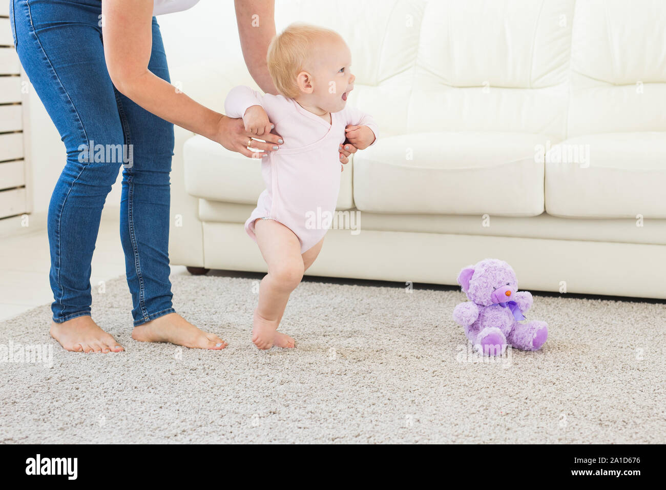 little girl first steps with the help of mom Stock Photo - Alamy
