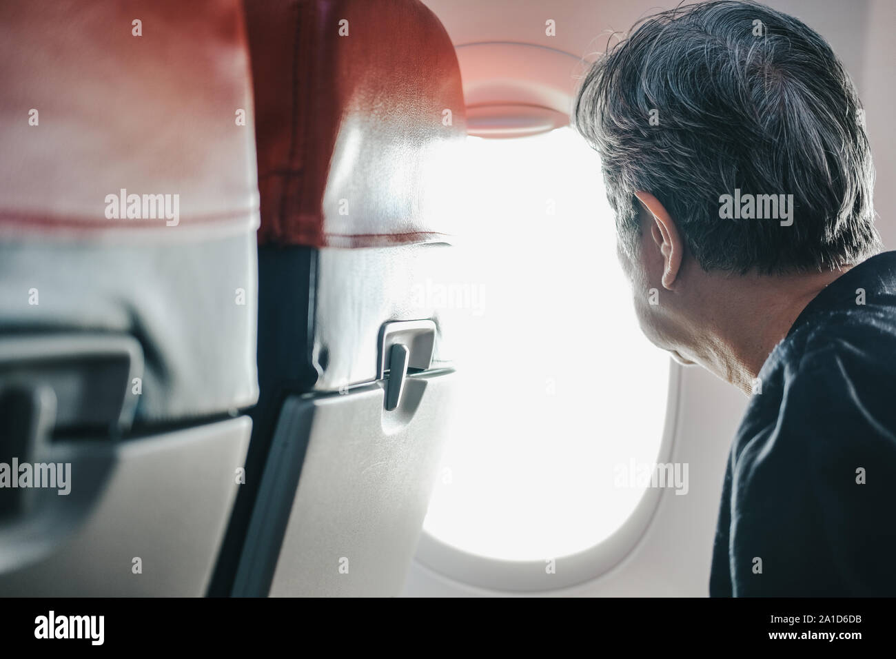 Woman looking through window of plane hi-res stock photography and ...