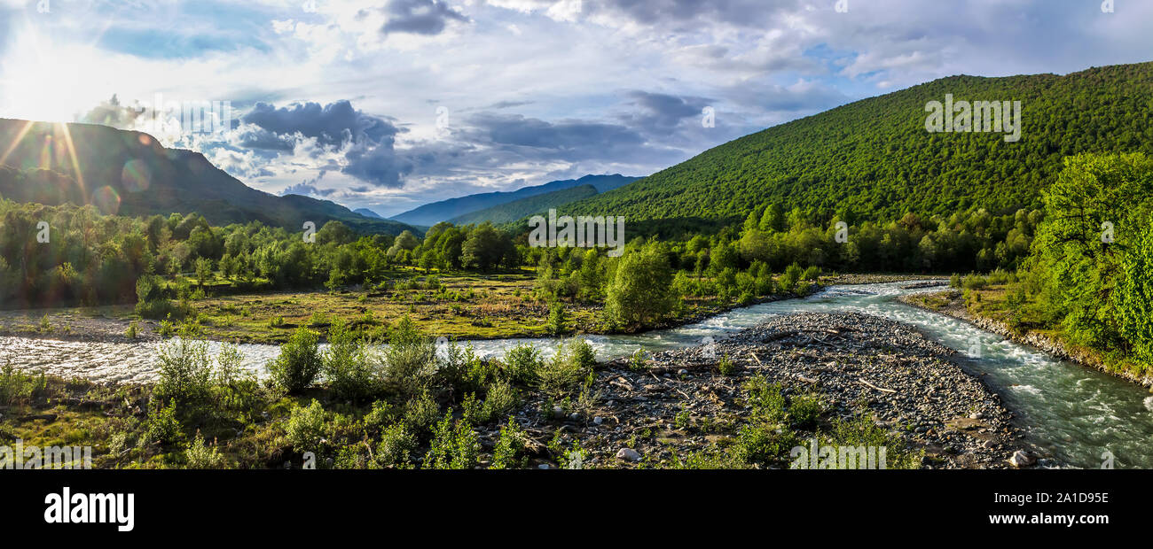wide panorama of mountain landscape of Abkhazia river at sunset with ...