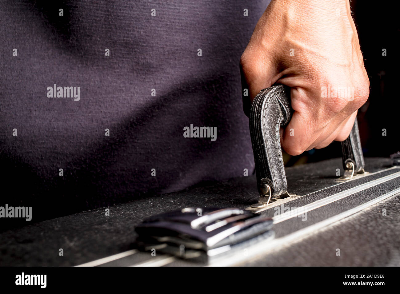 man carries a black suitcase in his hand on the handle Stock Photo - Alamy
