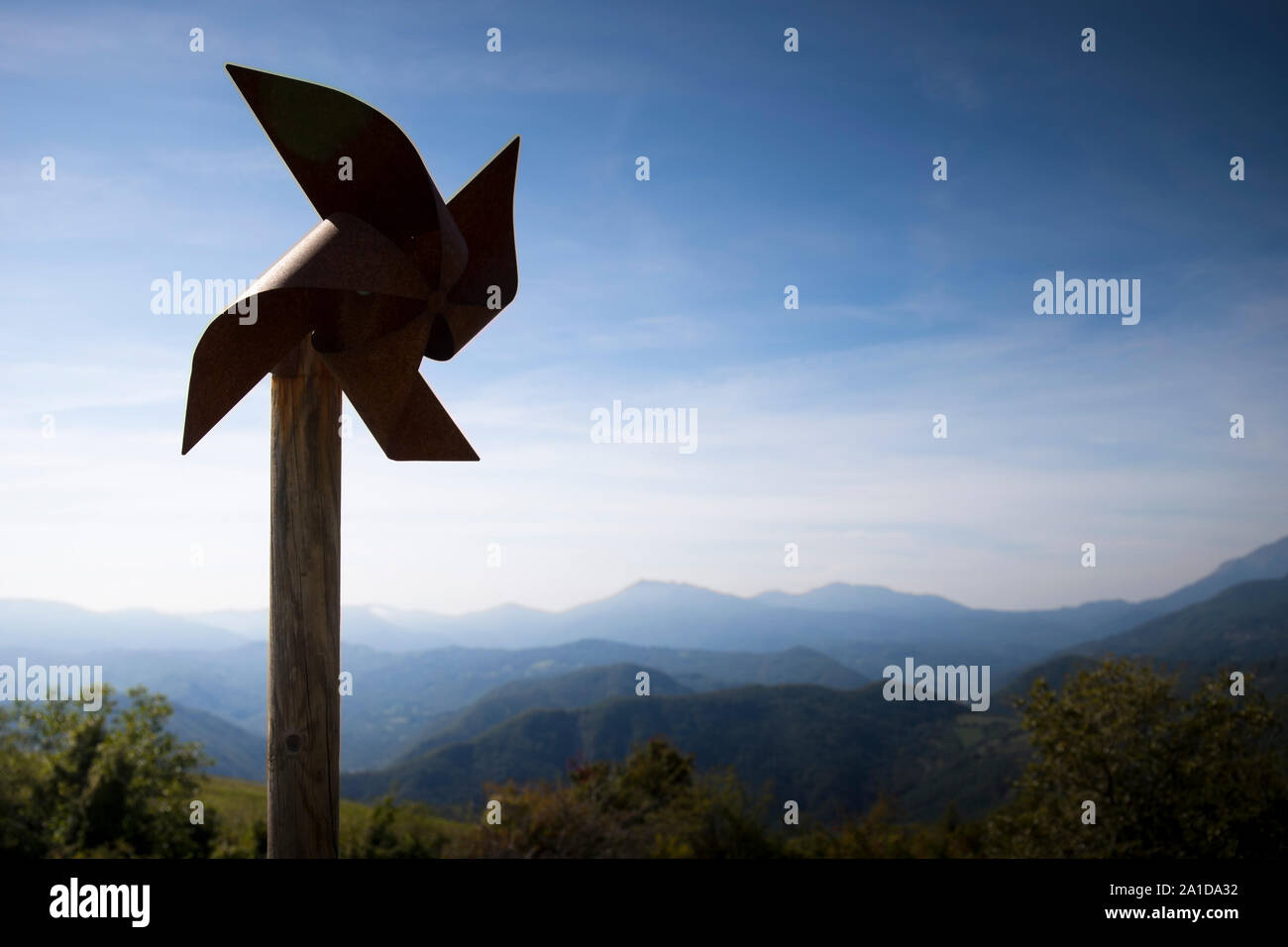 Big metal pinwheel with hills landscape and blue sky. Background or ...