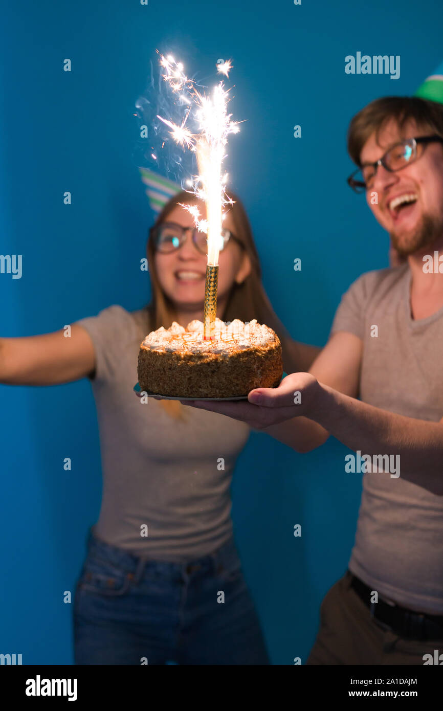 Cheerful young couple charming guy and cute girl in paper hats make ...