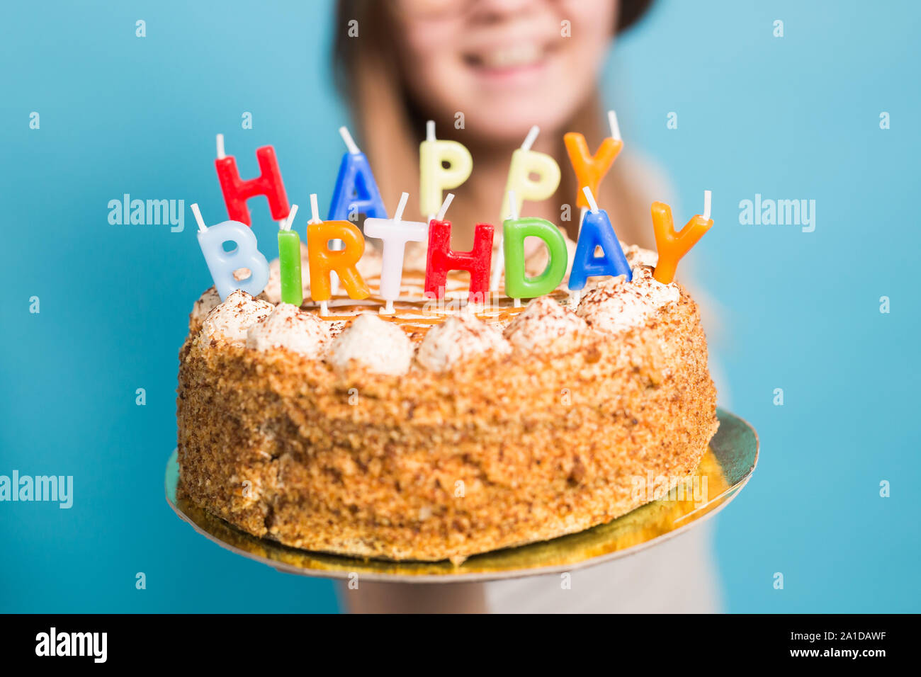 Crazy funny girl in a paper hat and glasses holding a big birthday cake ...