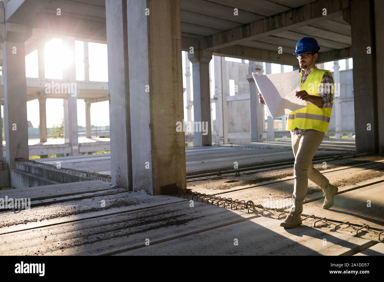 Engineer working on construction site and holding blueprint Stock Photo ...