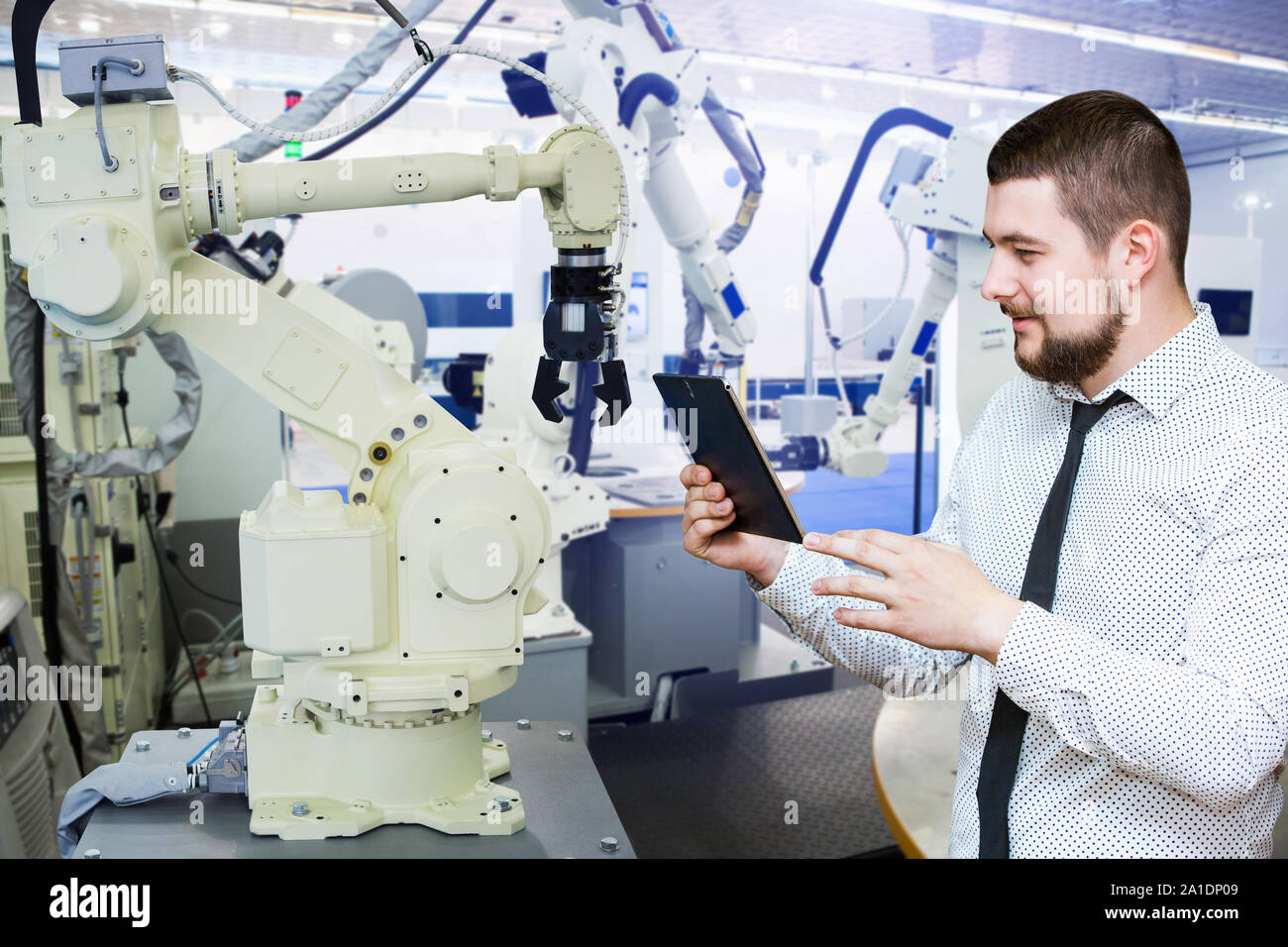 Engineer with teach pendant device. Programming robot with robotic arm ... Engineer with teach pendant device. Programming robot with robotic arm ...