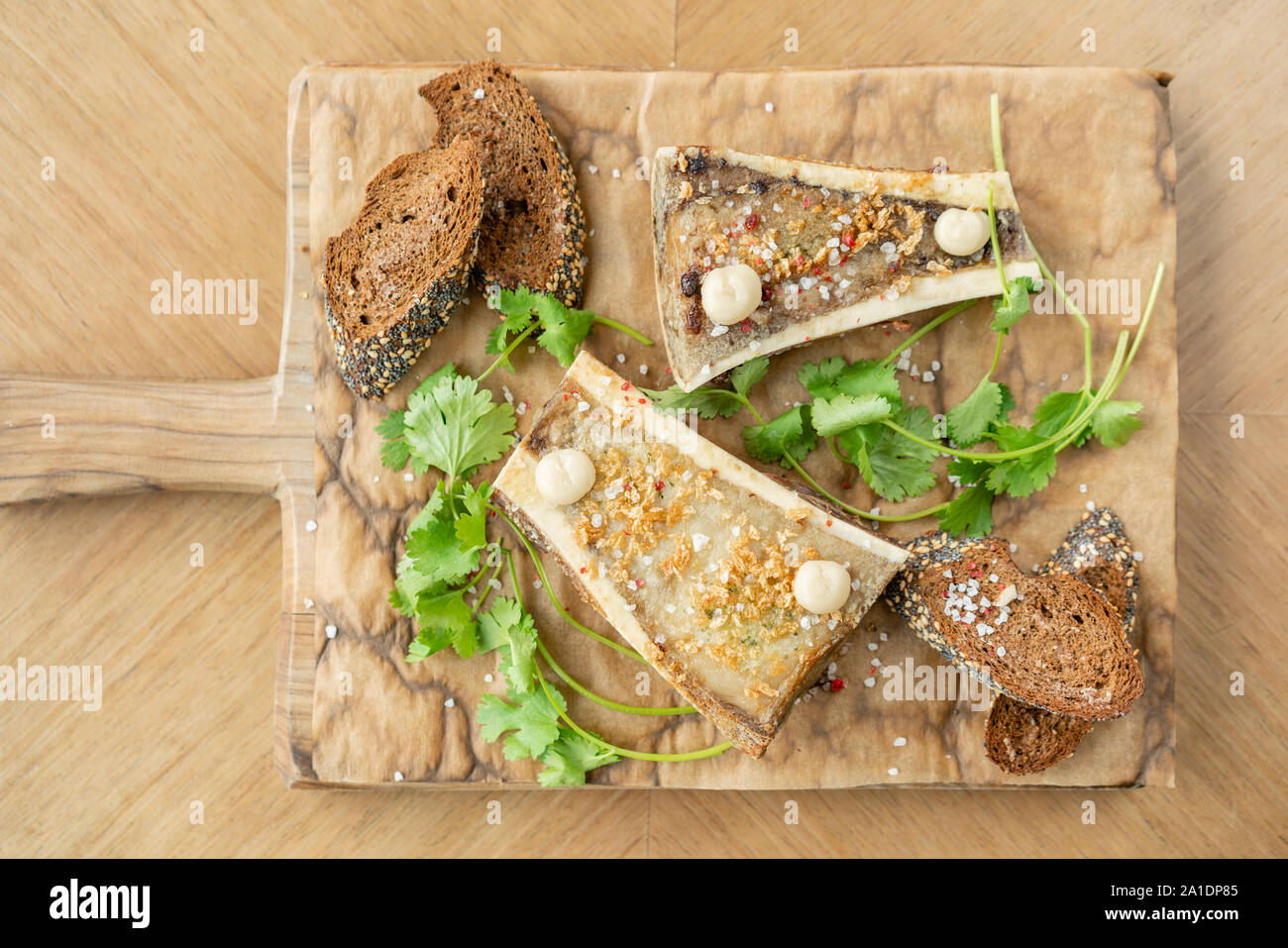 Beef bone marrow with chimichurri sauce and toasted bun. Served on a ...