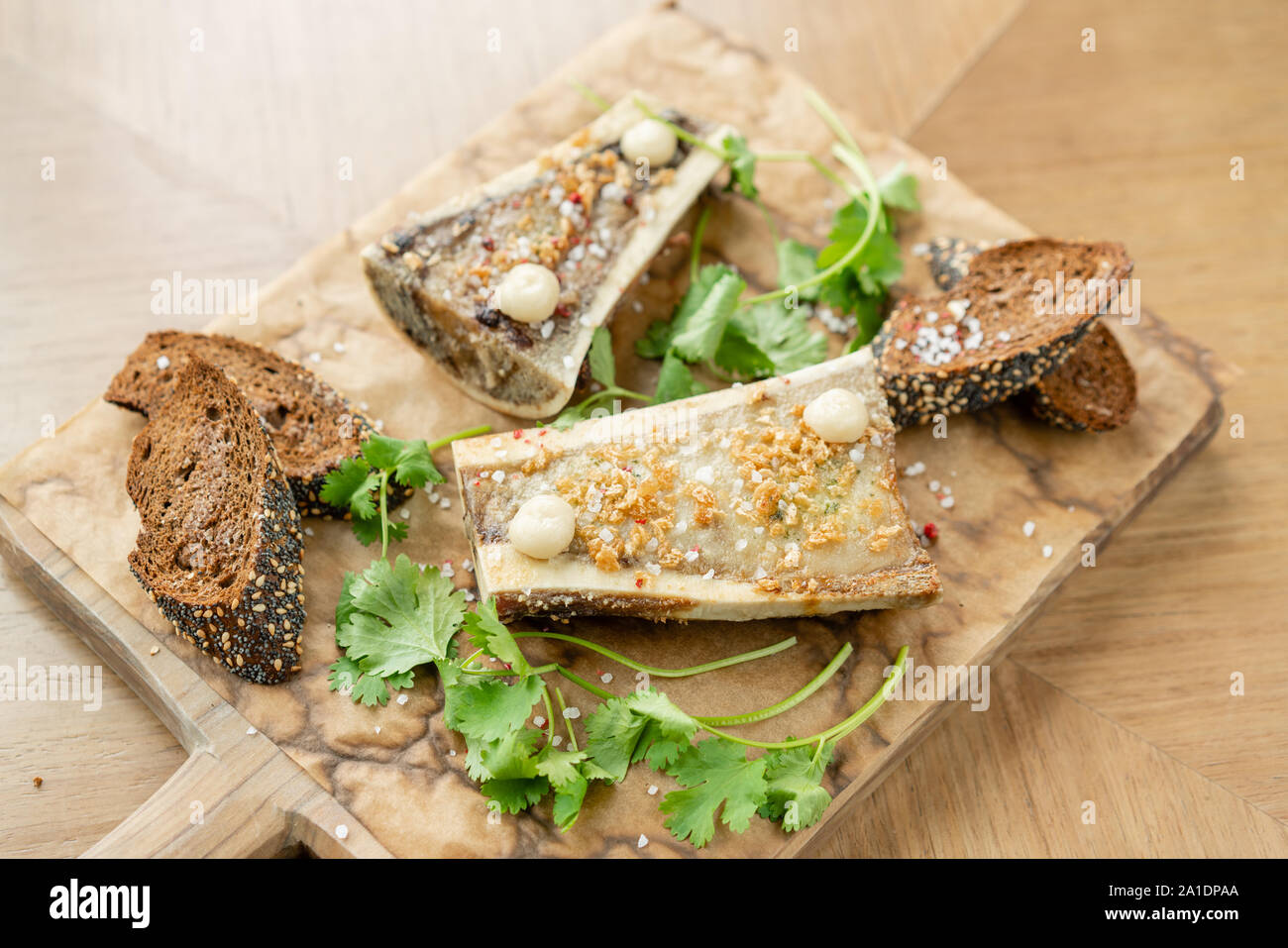 Beef bone marrow with chimichurri sauce and toasted bun. Served on a ...