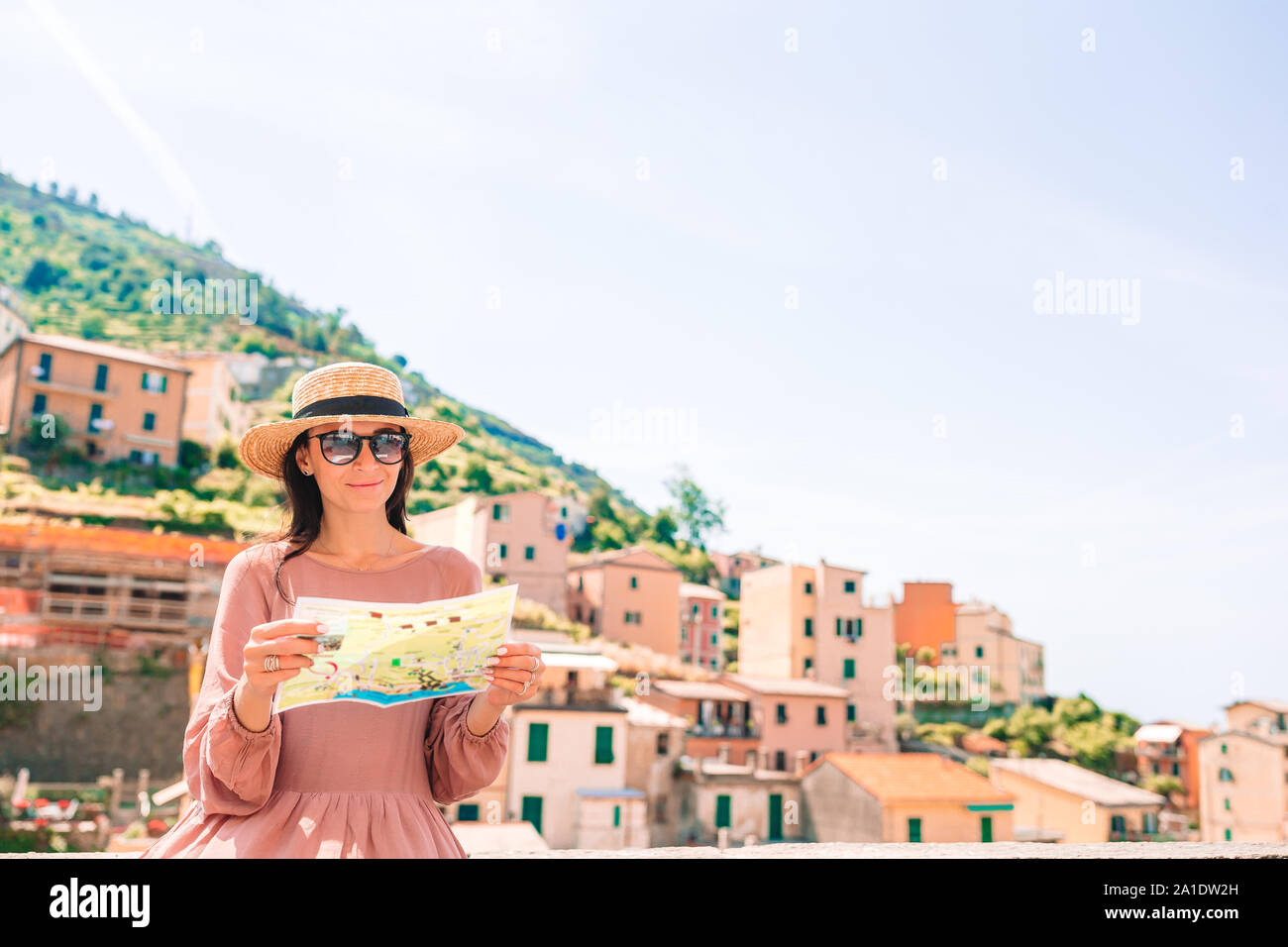 Young woman with great view and map at old village Riomaggiore in ...