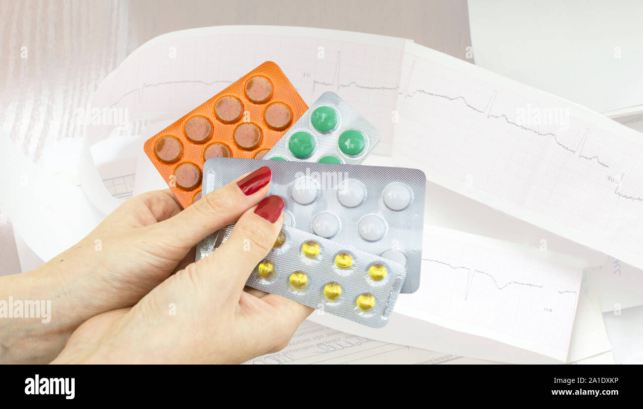 Different pharmaceutical tablets in women's hands on the background ...