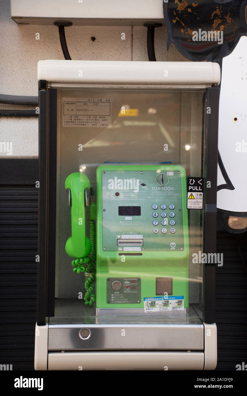 Old public telephone in booth for people use at outdoor of building in ...