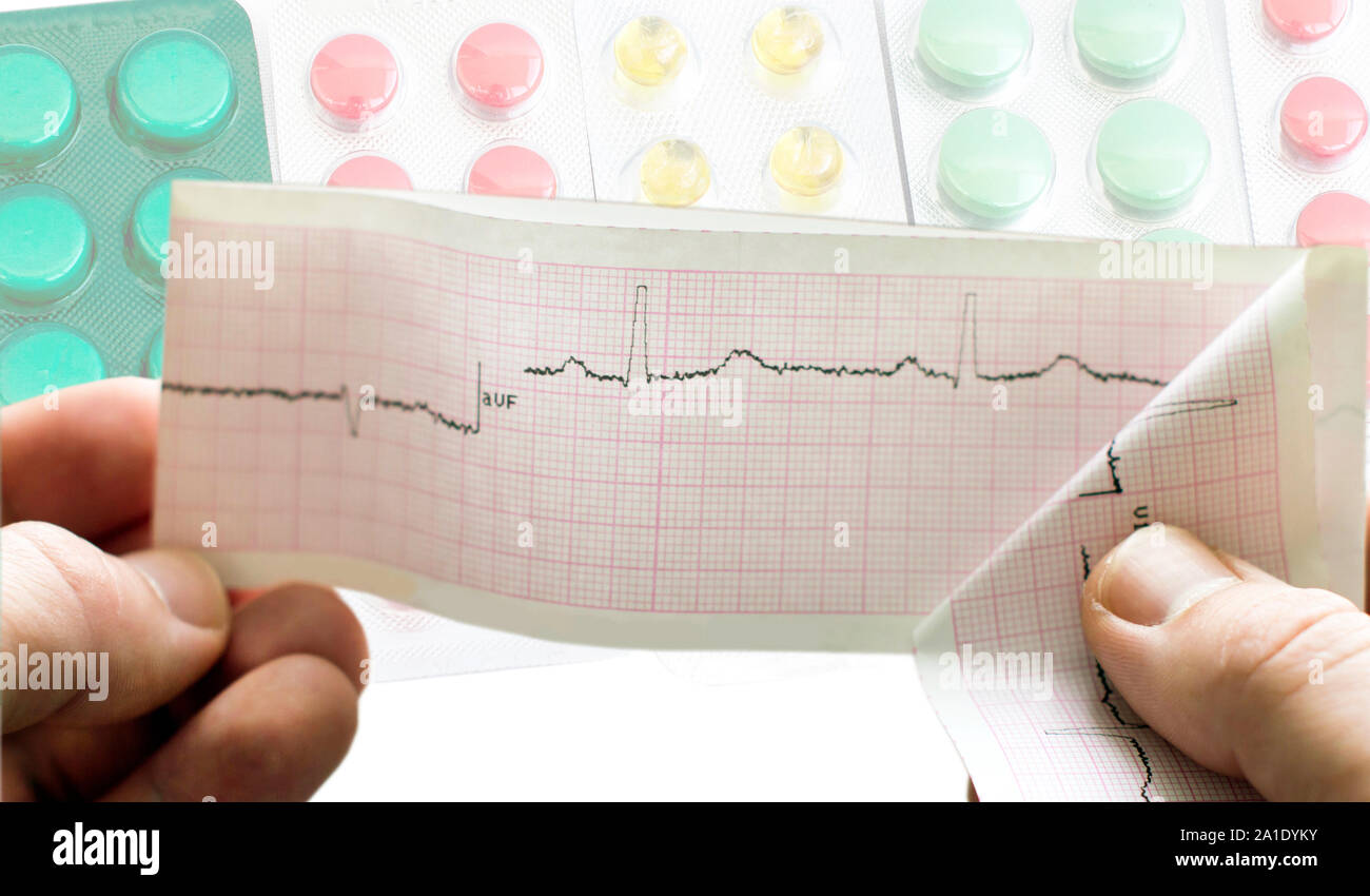 ECG in the hands of doctors against the background of different tablets ...