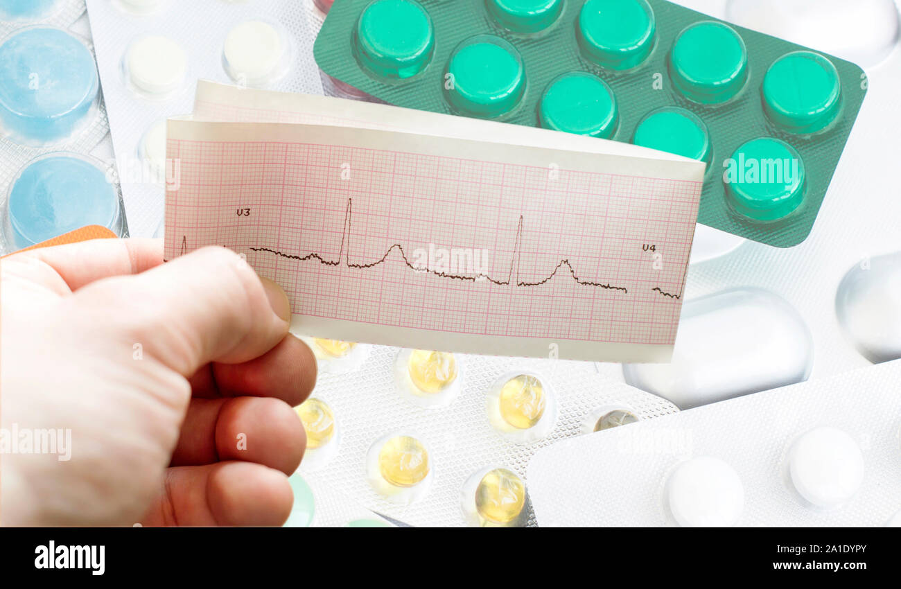 ECG in the hands of doctors against the background of different tablets ...