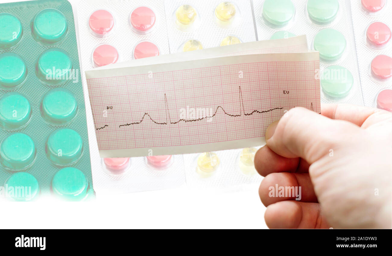 ECG in the hands of doctors against the background of different tablets ...