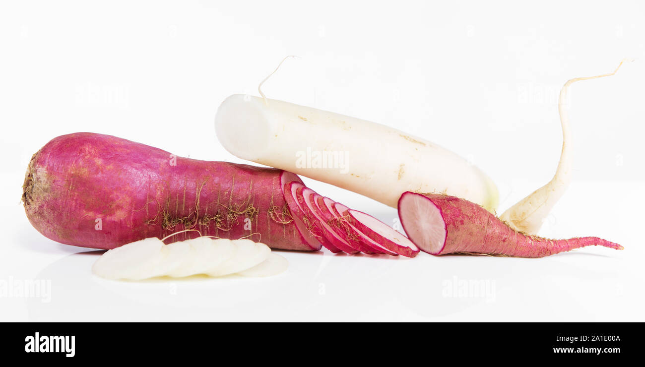 red and white radish, unpeeled and sliced in front of white Stock Photo ...