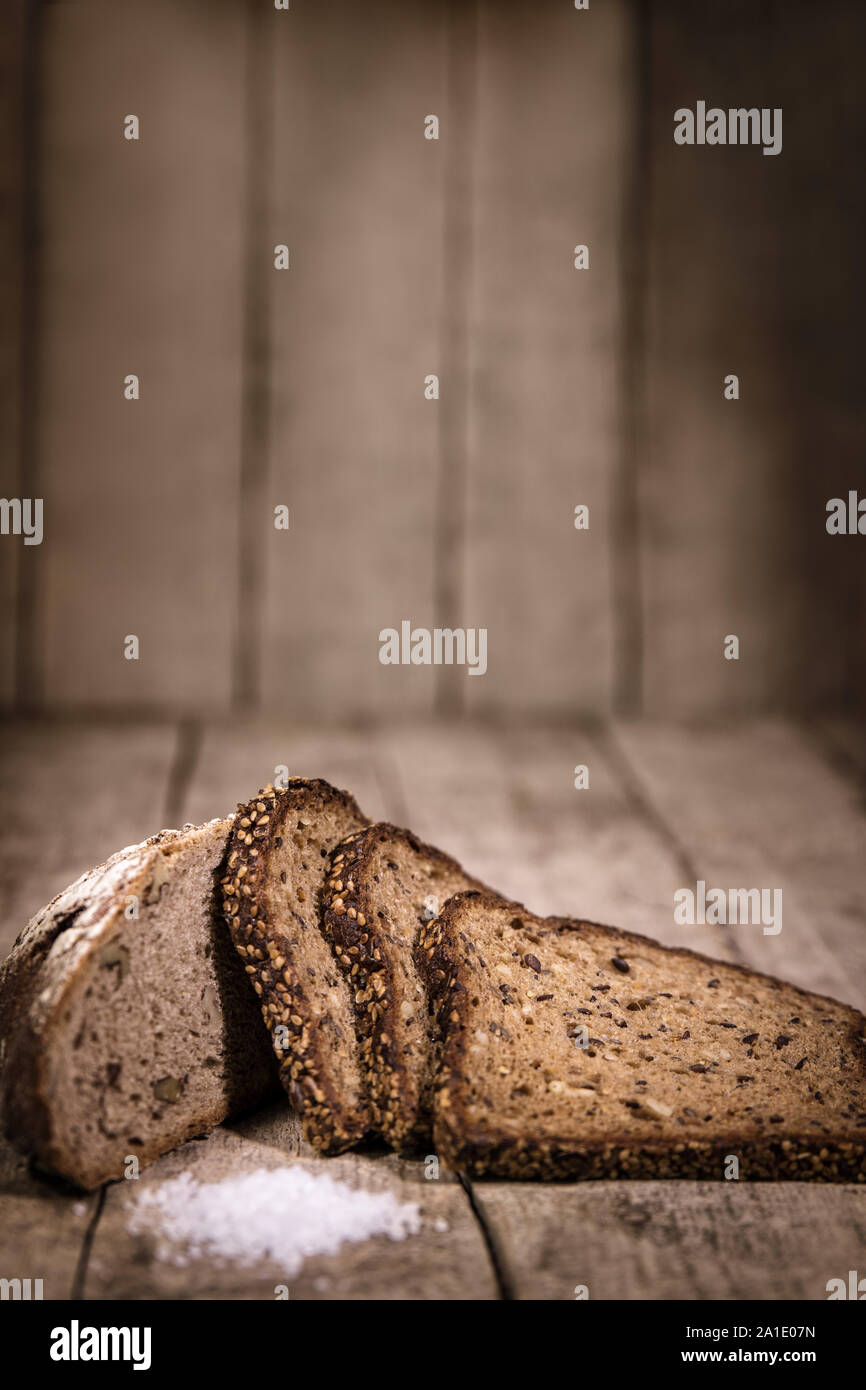 traditional german dark bread, sliced on a rustic wooden background ...