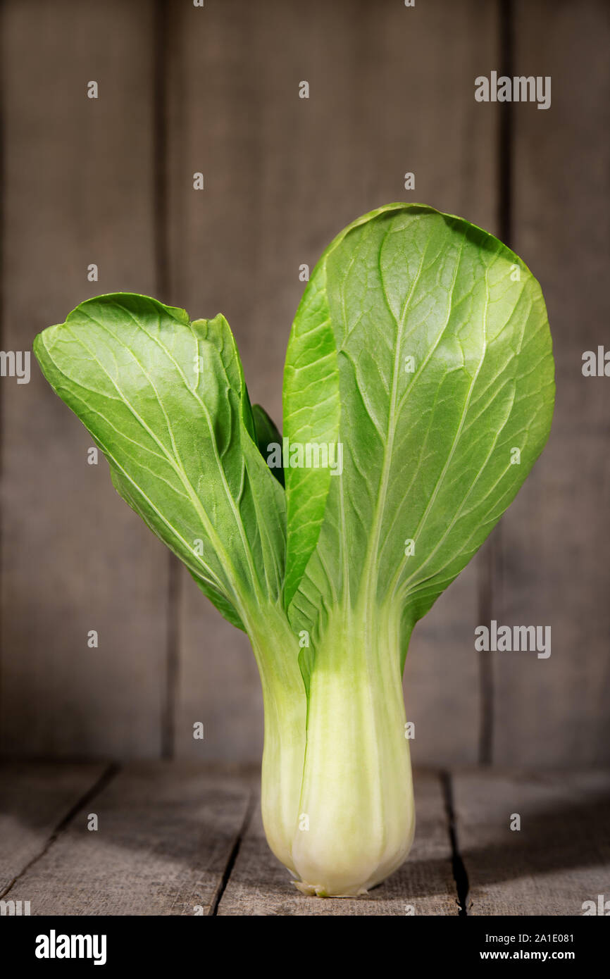 fresh pak choi in front of a rustic wooden background Stock Photo - Alamy