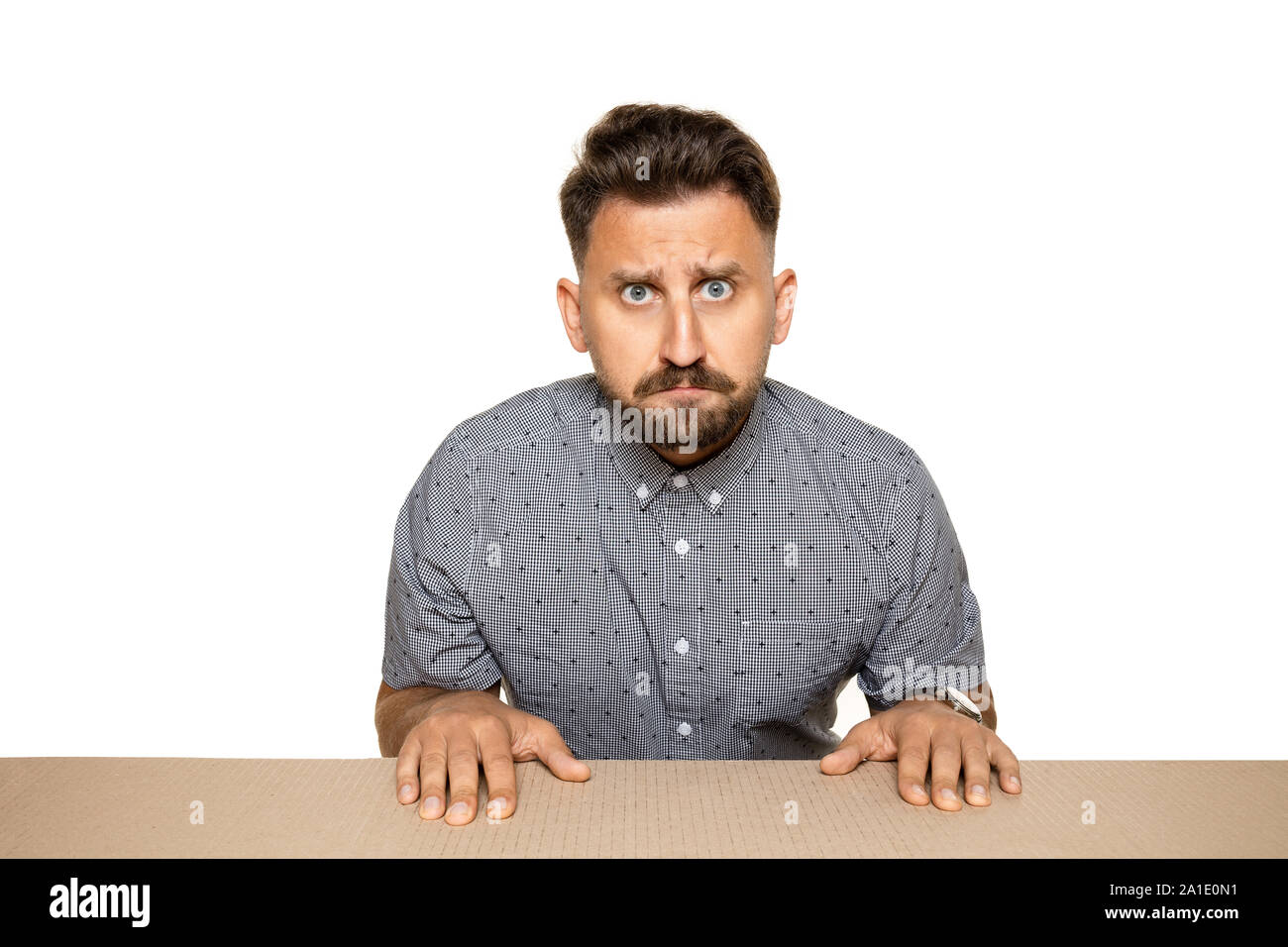 Shocked and upset man opening the biggest postal package. Sad and ...