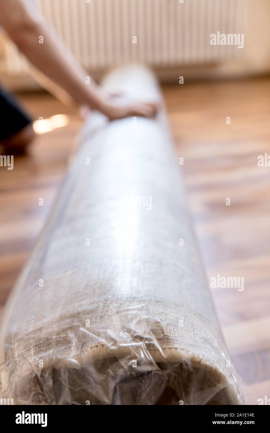 New packed and rolled carpet on the floor, plastic packaging Stock ...