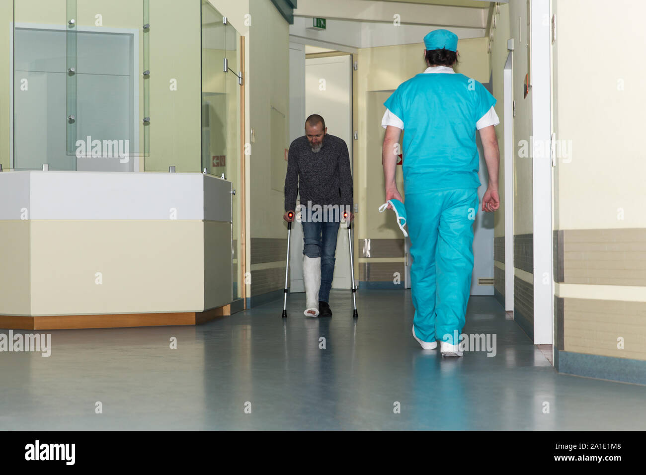 male patient with cast and surgeon walking on hospital corridor Stock ...