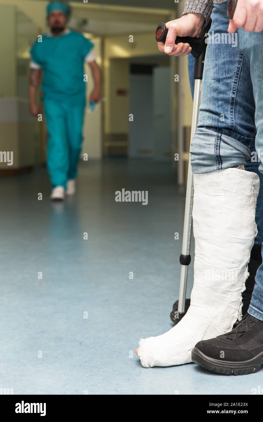 male patient with cast and surgeon walking on hospital corridor Stock ...