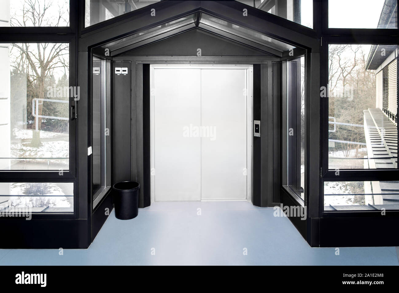 entrance of an elevator or lift, indoors with windows at the left and ...
